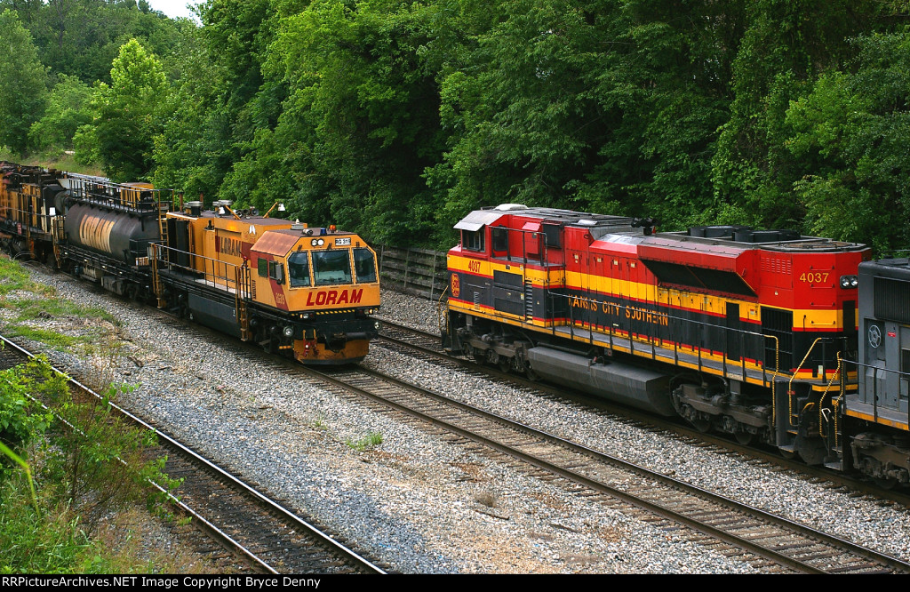 KCS 4037 approaches LORAM rail grinding train in Texas Ave. cut